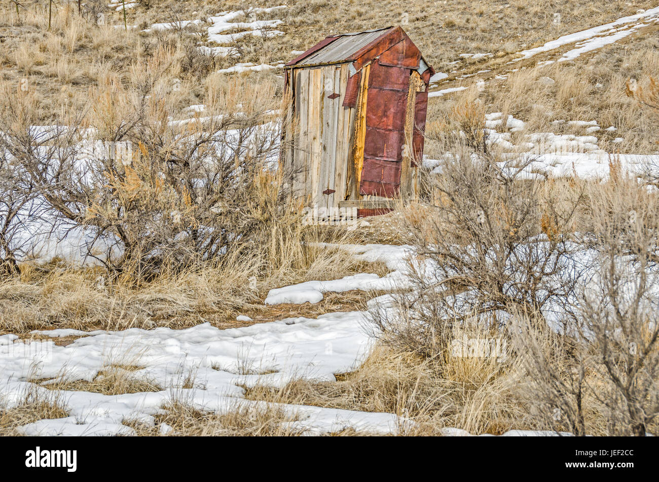 Outhouse with rusty hinges and rusty metal on the side in a Montana ...