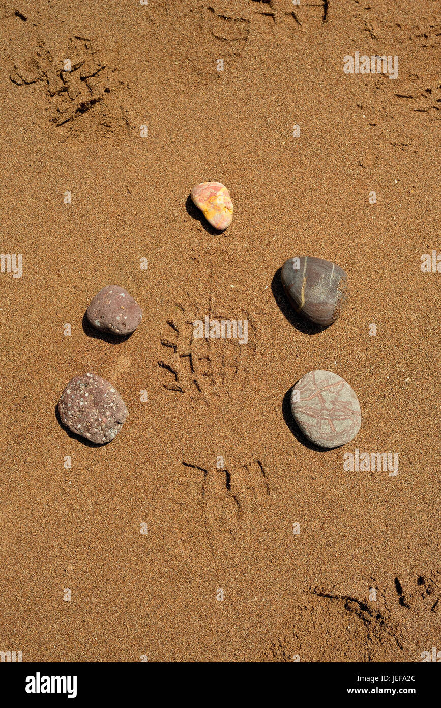 Stones and footprints on the beach Stock Photo - Alamy