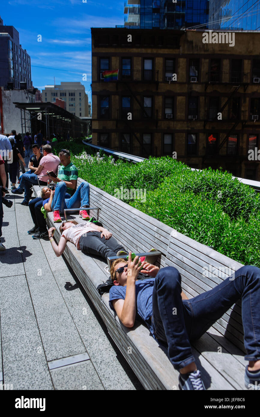 People laying on a bench sunbathing in the High Line Park, Manhattan ...