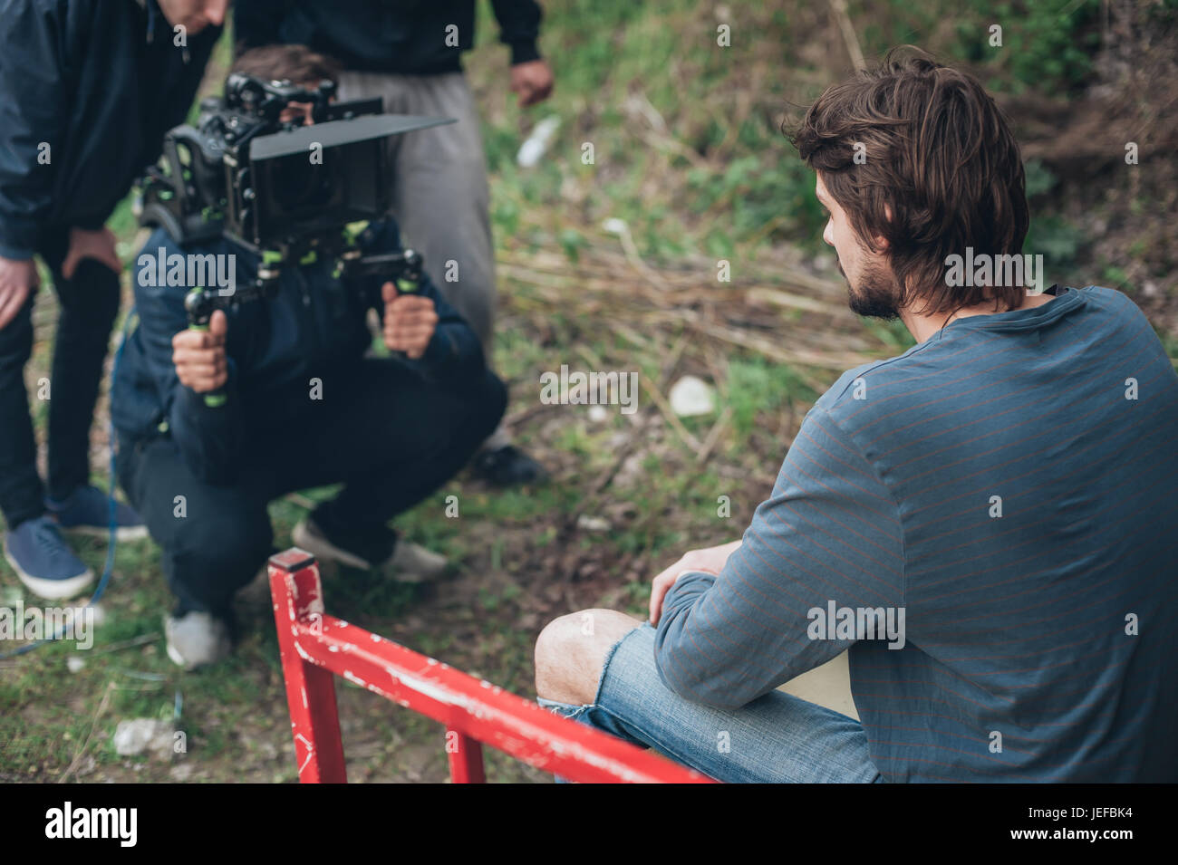 Behind the scene. Actor in front of the camera on the film set outdoor ...