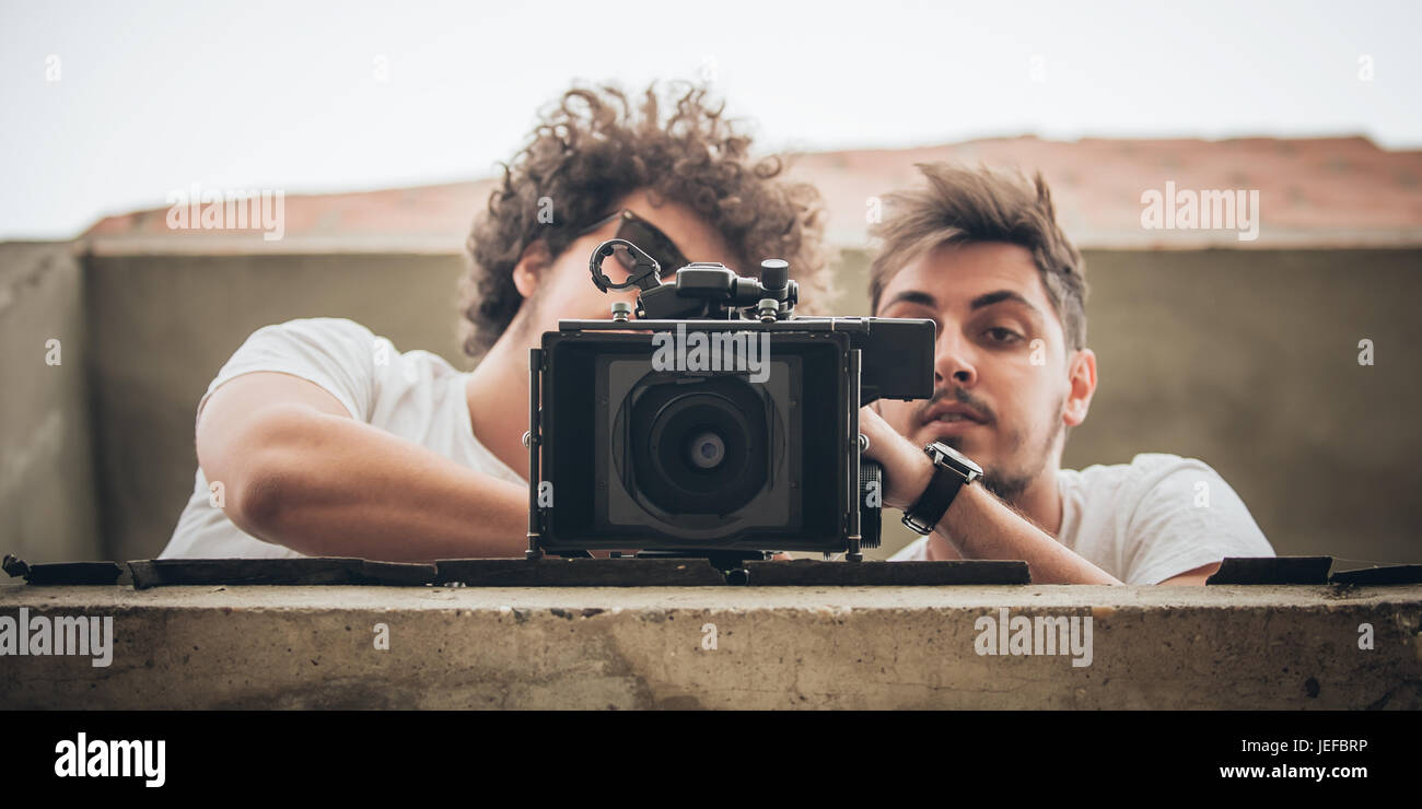 Behind the scene. Cameraman and assistant shooting the film scene with ...