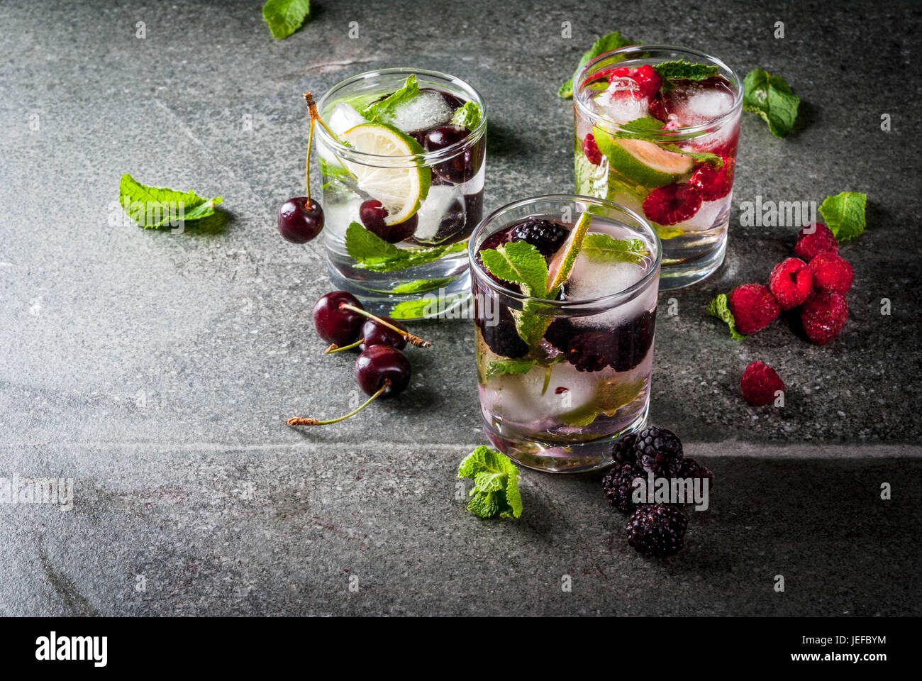 Set of traditional summer refreshing drinks berry mojito. With lime, mint leaves, blackberries ...
