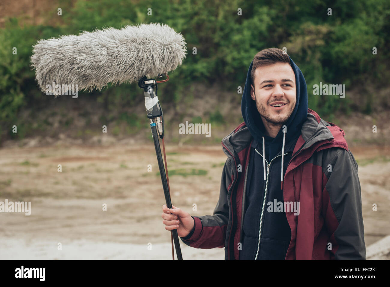 Behind the scene. Sound boom operator resting on the set and hold ...
