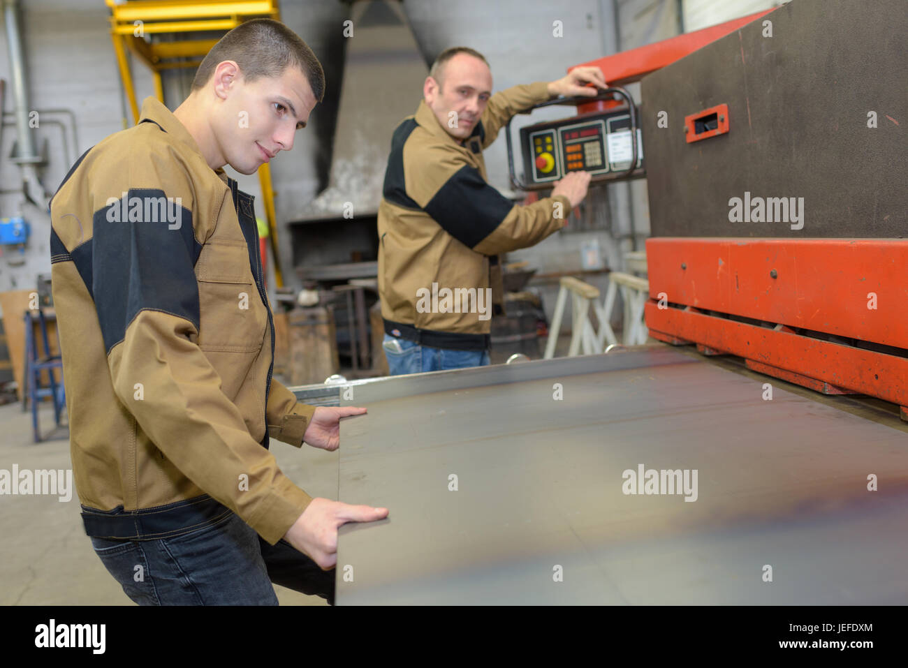 two worker in factory on the machine Stock Photo - Alamy