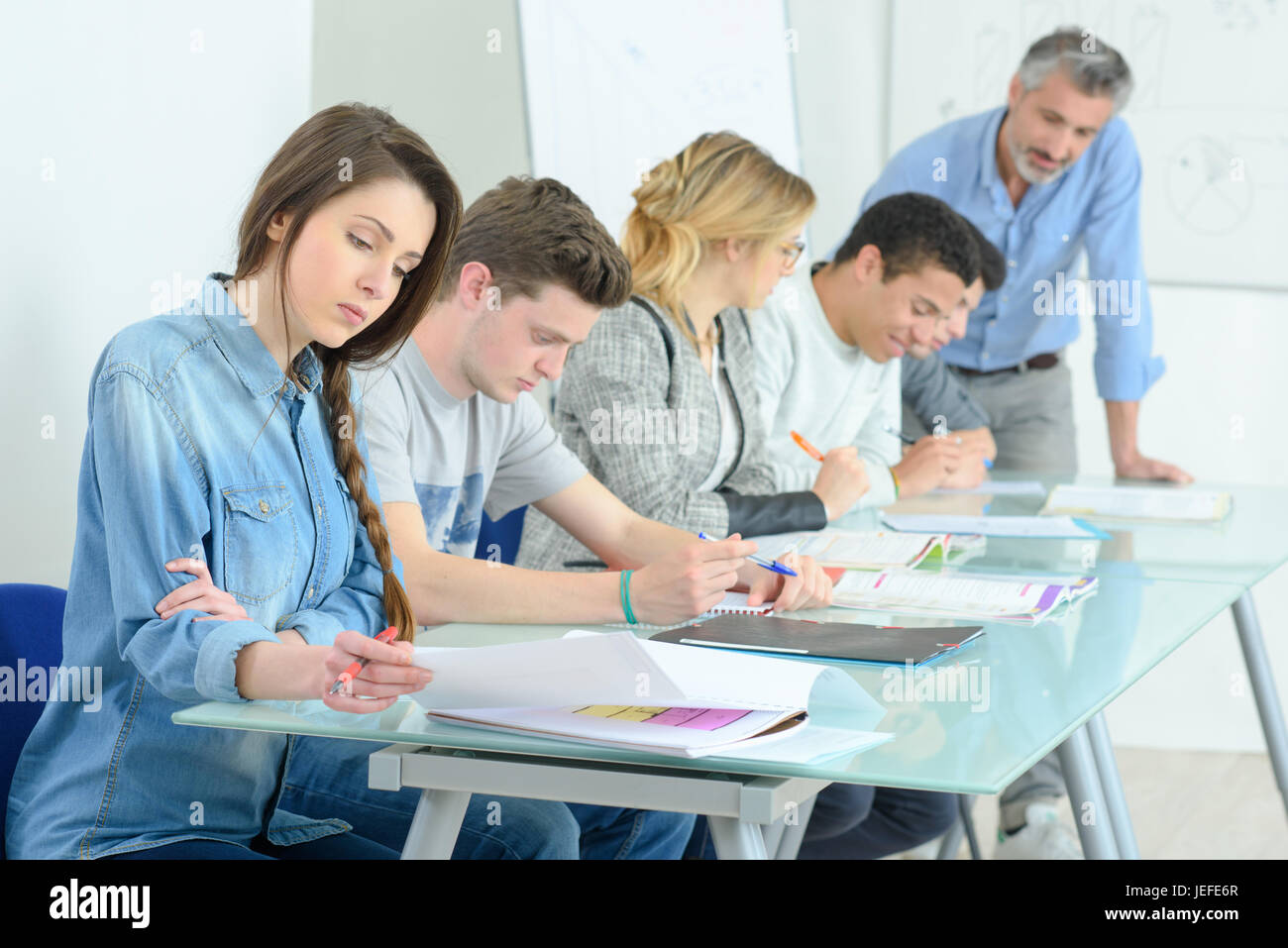 students discussing with teacher in classroom Stock Photo - Alamy