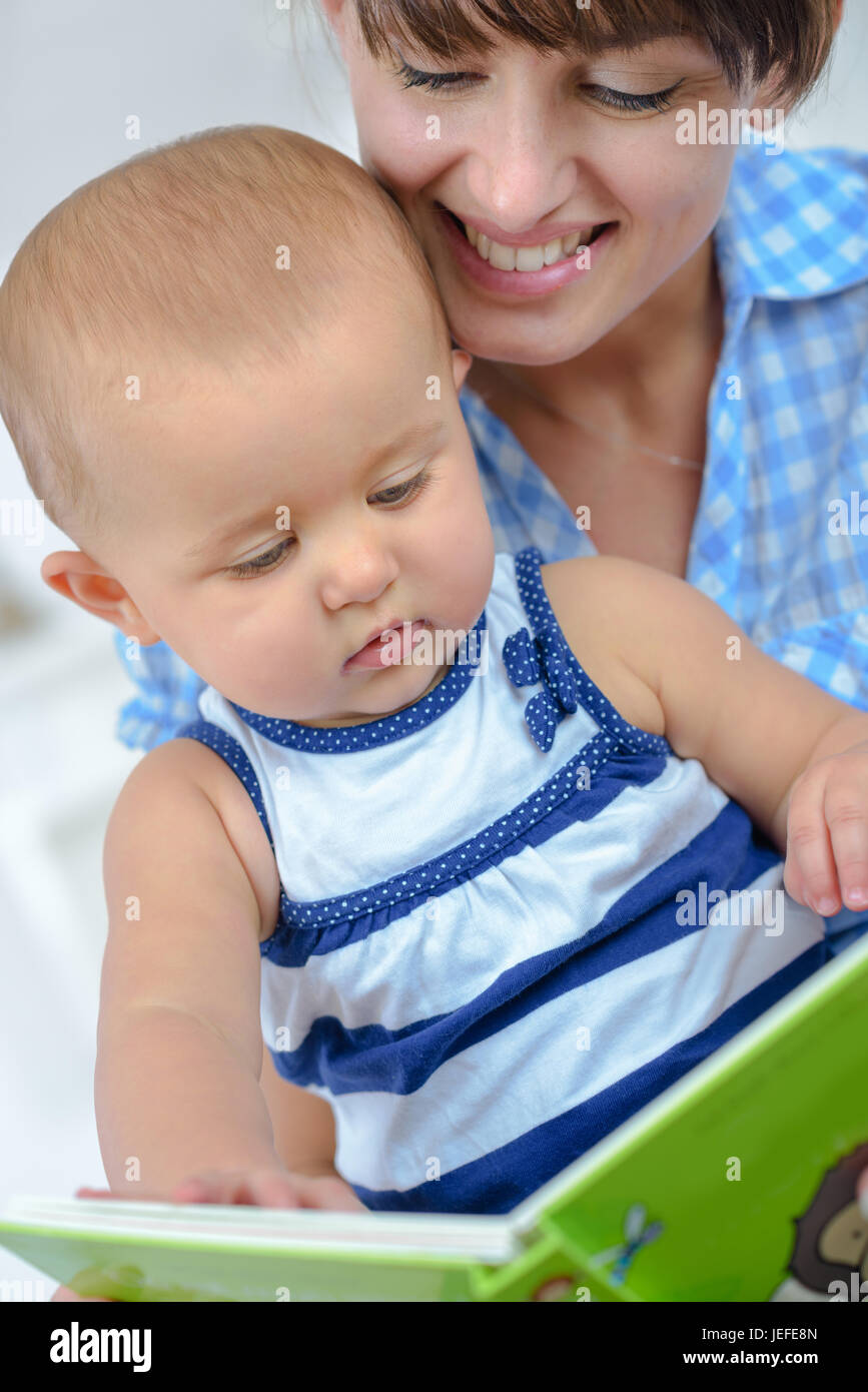 happy mother and baby reading book Stock Photo - Alamy
