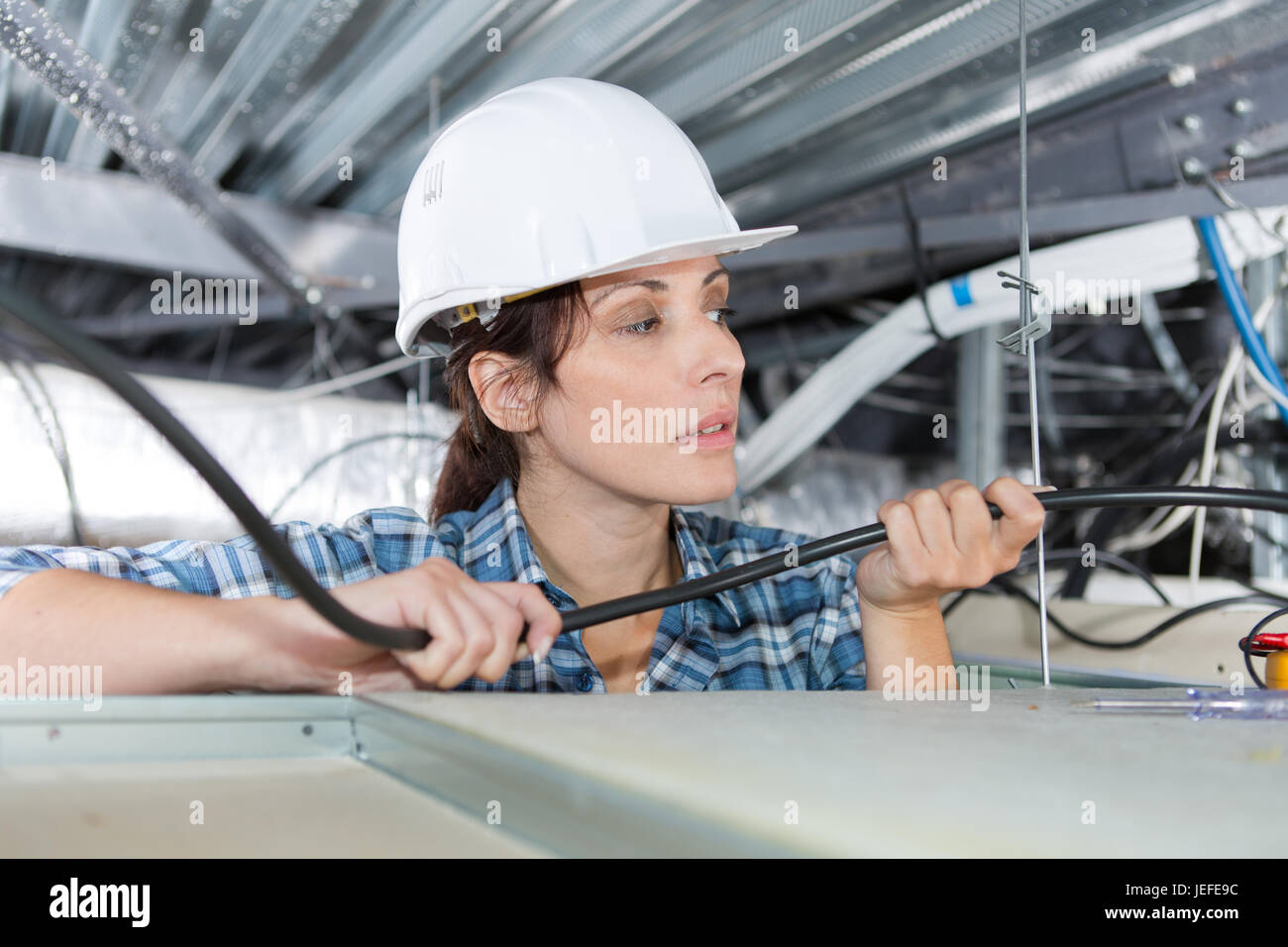 female worker checking wires and cables on the ceiling Stock Photo - Alamy