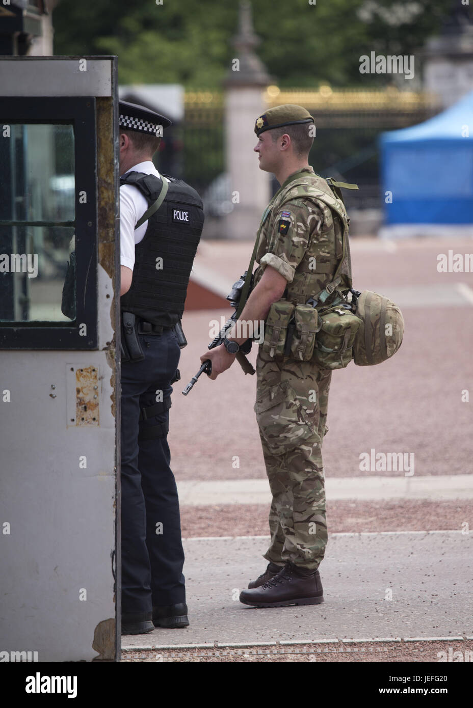Armed police and military protecting Buckingham Palace. Featuring ...