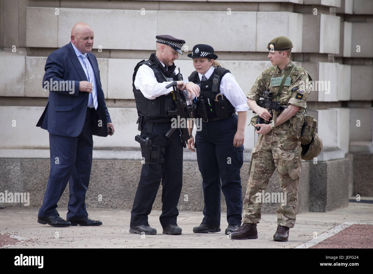 Armed police and military protecting Buckingham Palace. Featuring ...