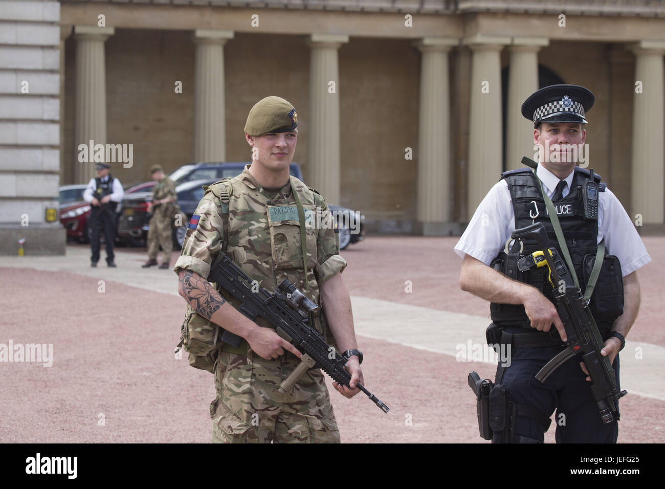 Armed police and military protecting Buckingham Palace. Featuring ...