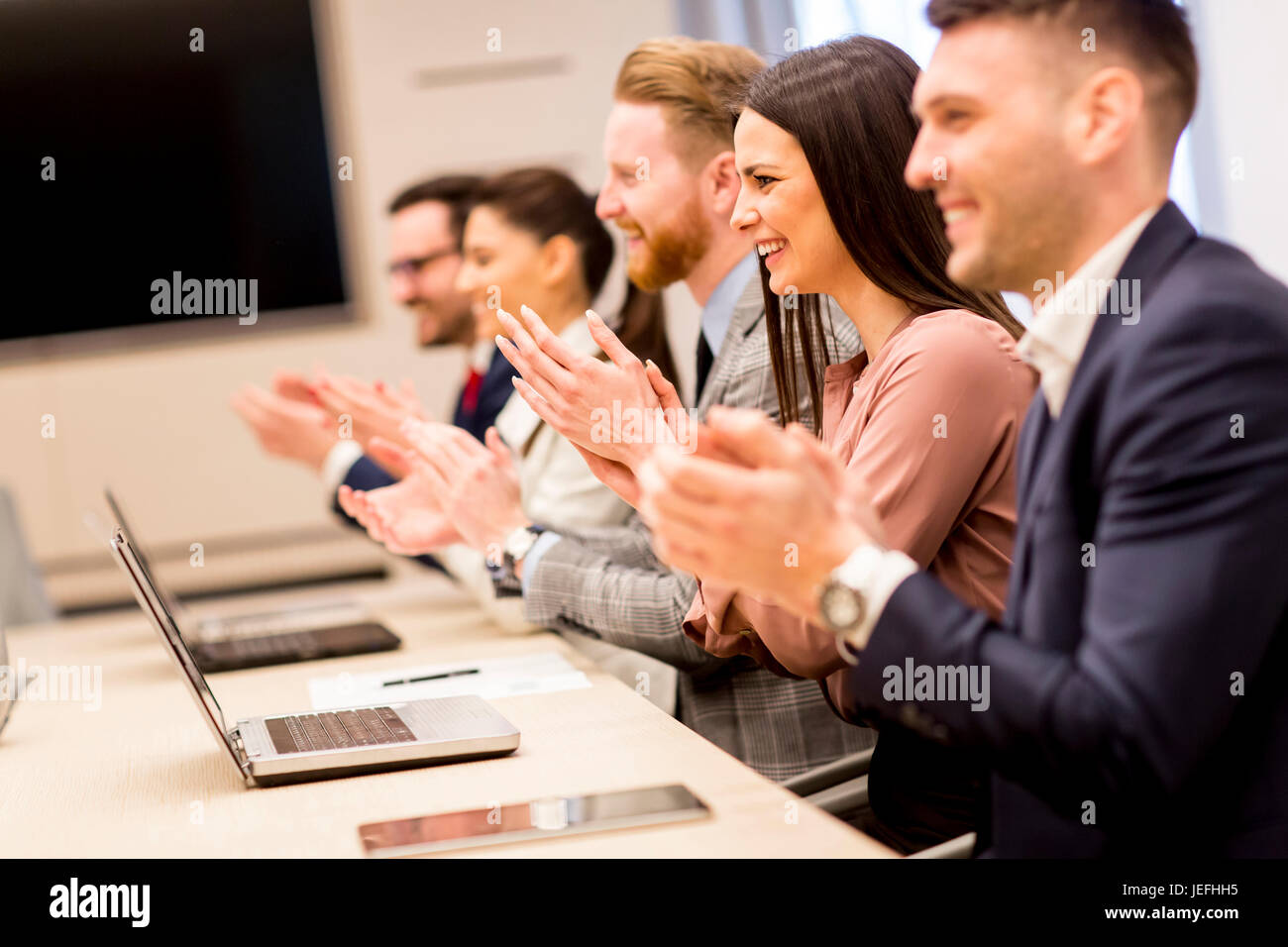 Happy smiling business team clapping hands during a meeting in office ...