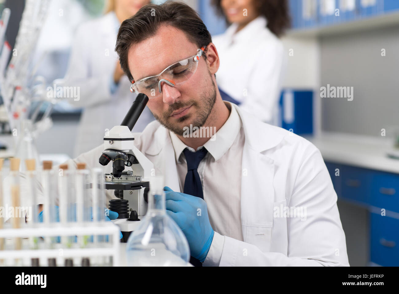 Medical professor looking through microscope hi-res stock photography ...