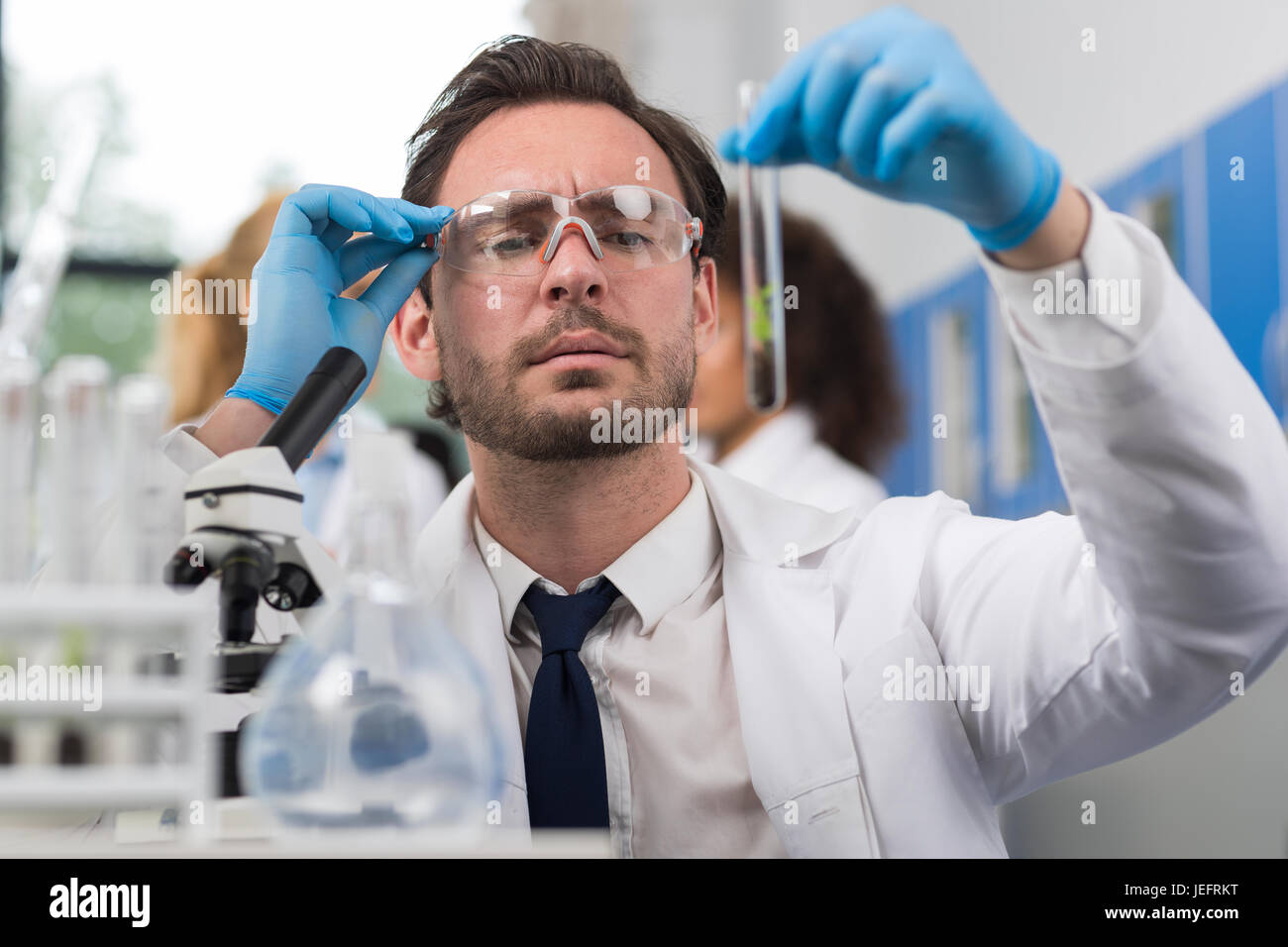 Scientist Analyzing Examining Sample Of Plant In Test Tube Workin In ...