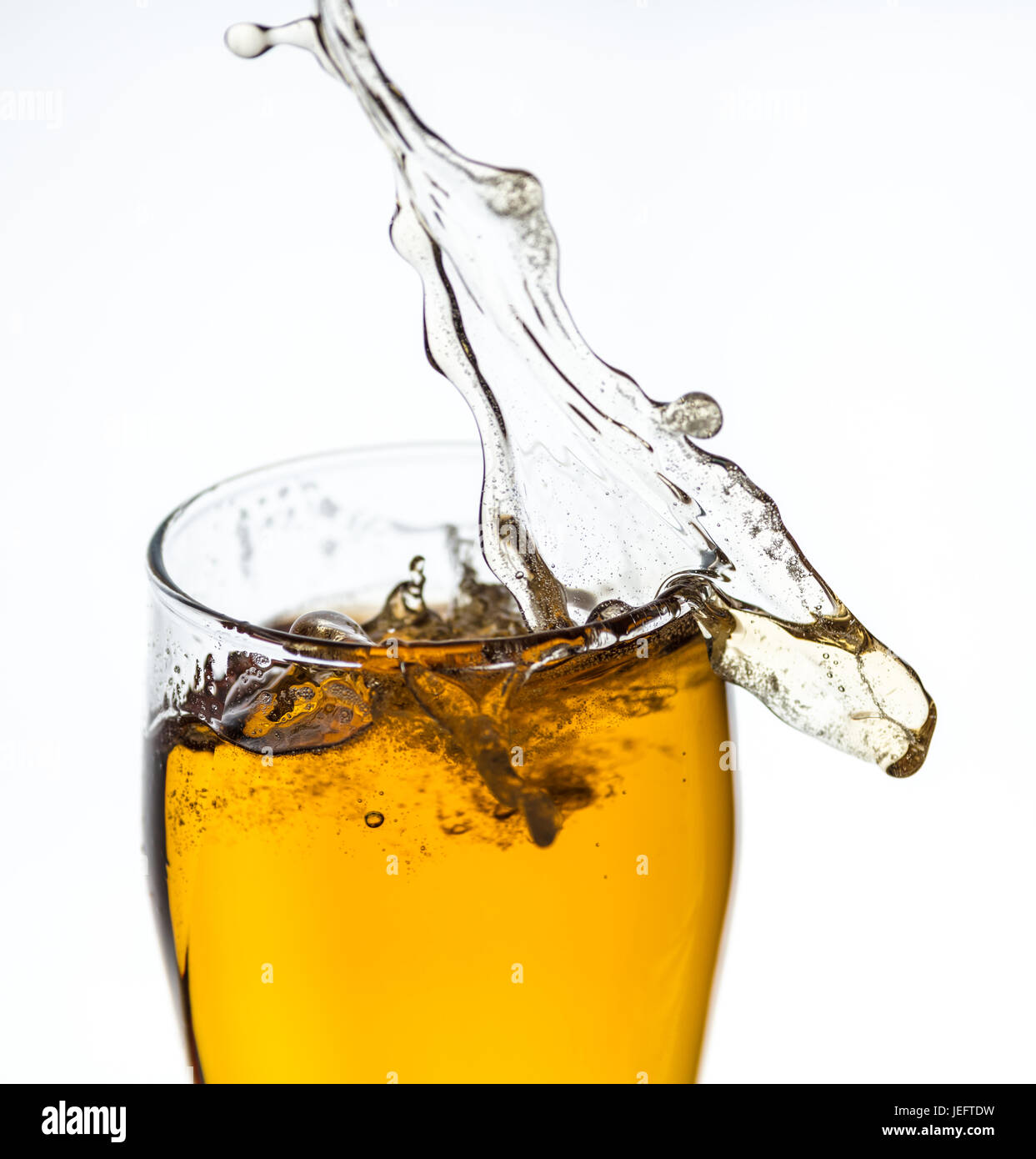 Splashing beer from a glass on white background Stock Photo - Alamy