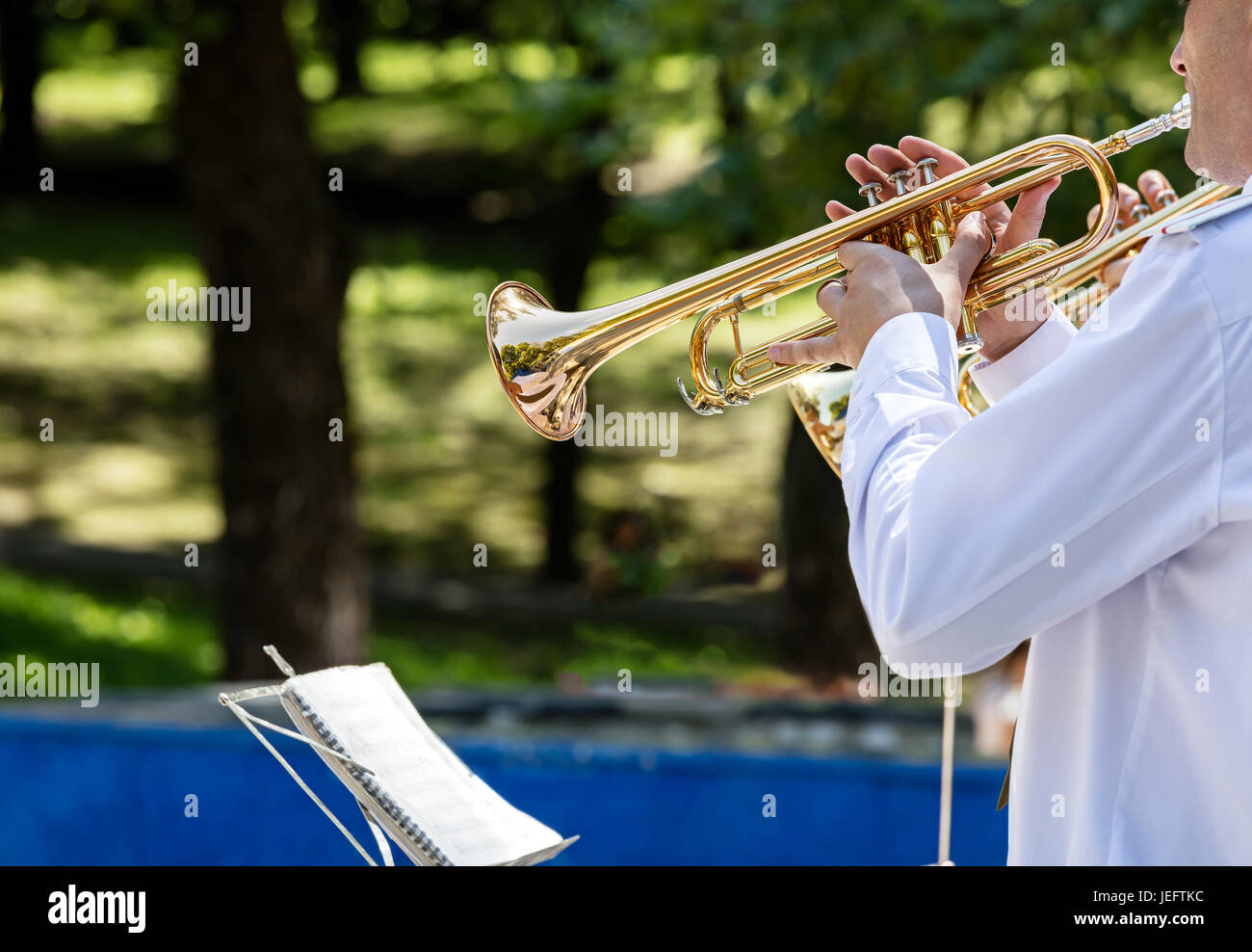 army brass band musician in uniform playing trumpet during live event ...