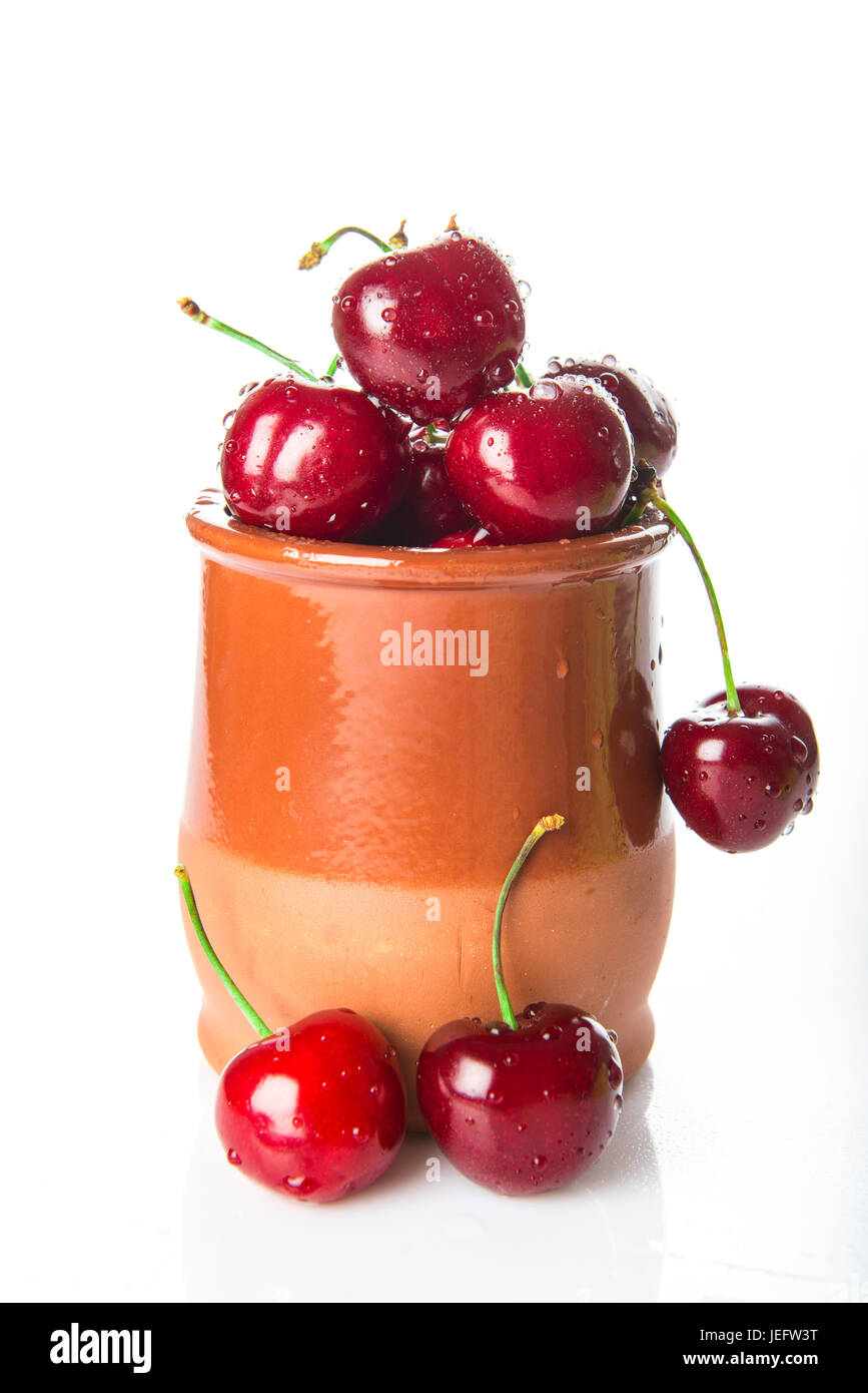 Clay pot with fresh cherries isolated on a white background Stock Photo ...