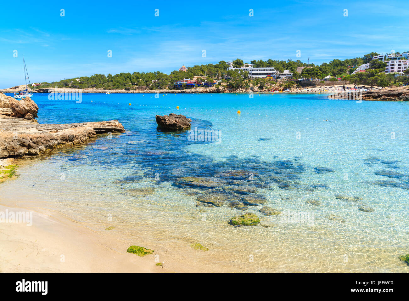 Idyllic Cala Portinatx beach with shallow crystal clear sea water ...