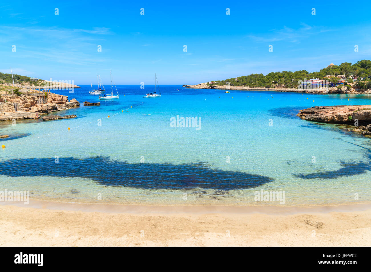 Idyllic Cala Portinatx beach with shallow crystal clear sea water ...