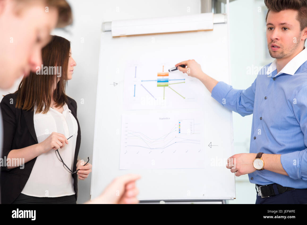 Executive Explaining Chart To Colleagues In Office Stock Photo - Alamy