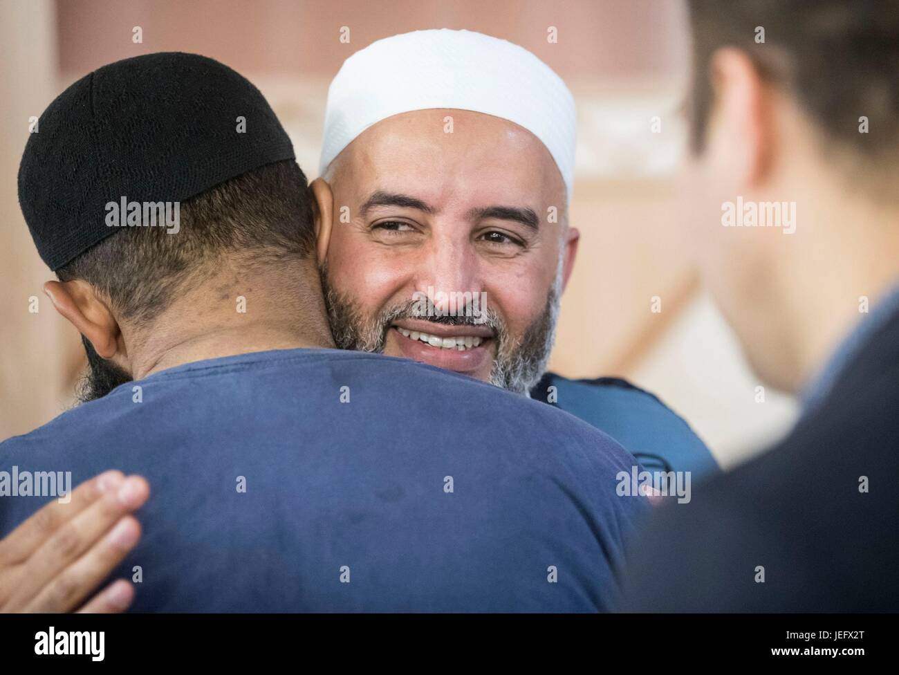Imam Dr Mohammed Taher hugs a worshipper following the Eid prayer the Eid prayer, which marks ...