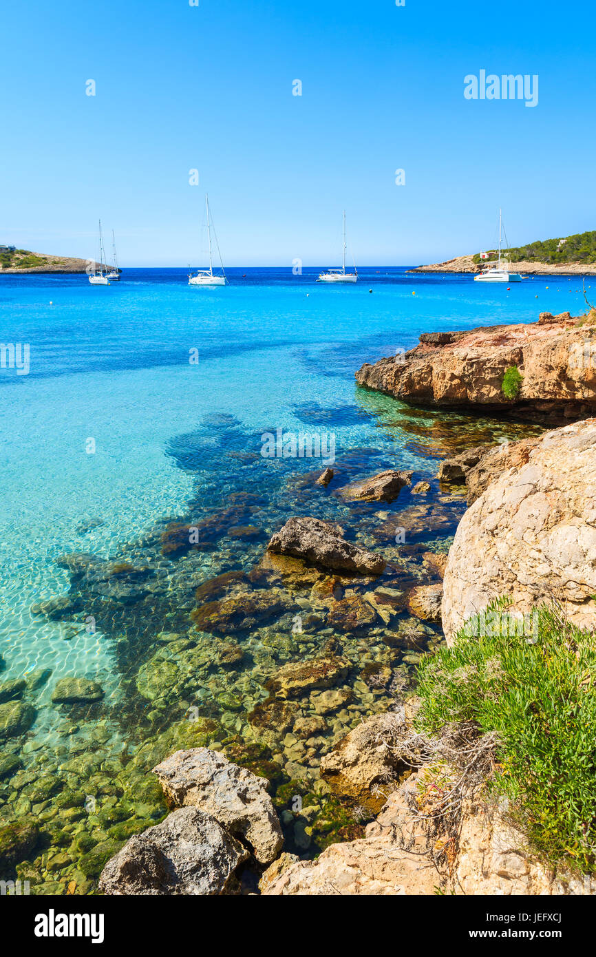 View of rocks in turquoise sea water on coast of Cala Portinatx bay ...