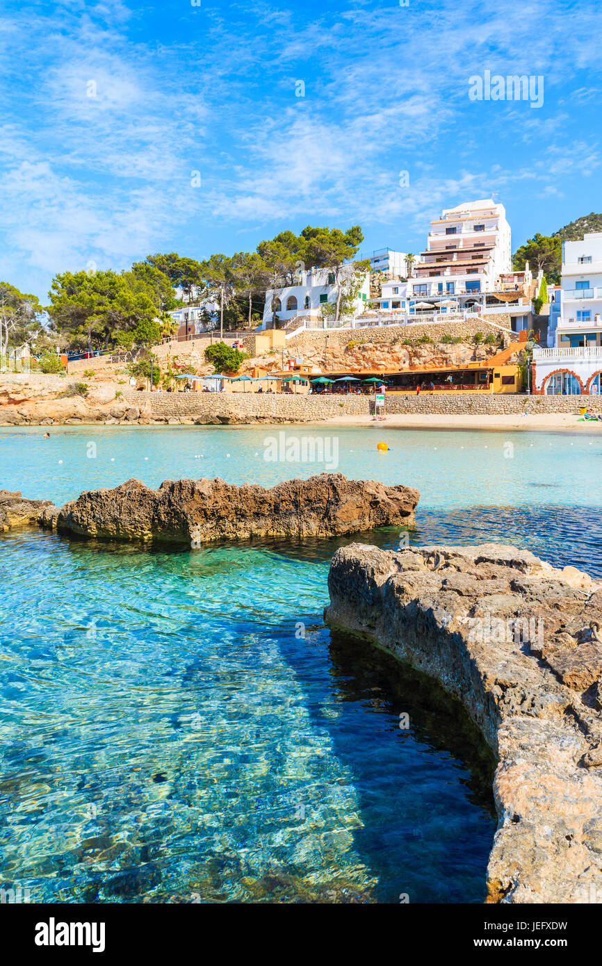 Hotel and restaurant buildings in Cala Portinatx bay with azure blue ...