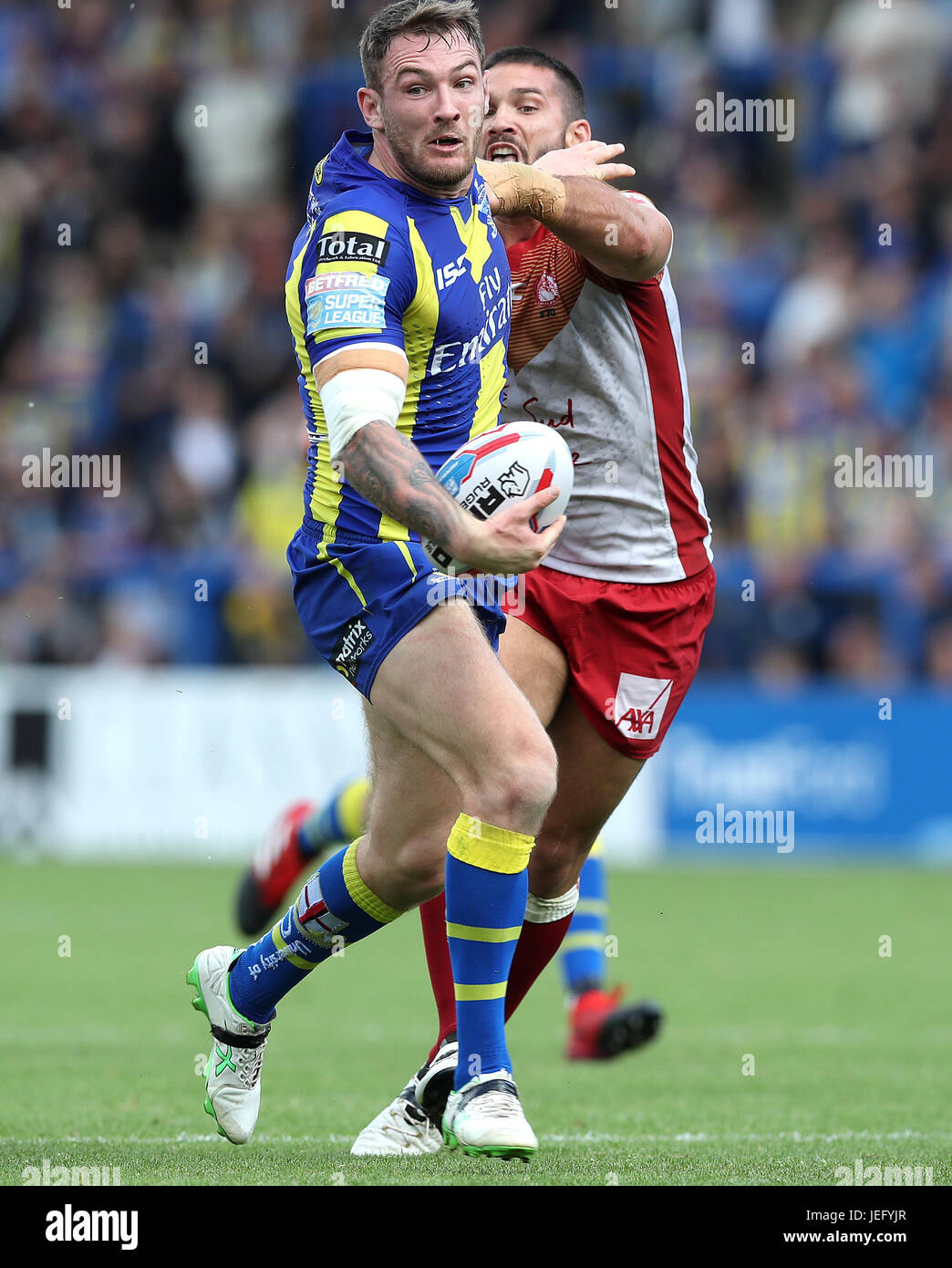 Warrington Wolves' Daryl Clark is tackled by Catalans Dragons' Jason ...