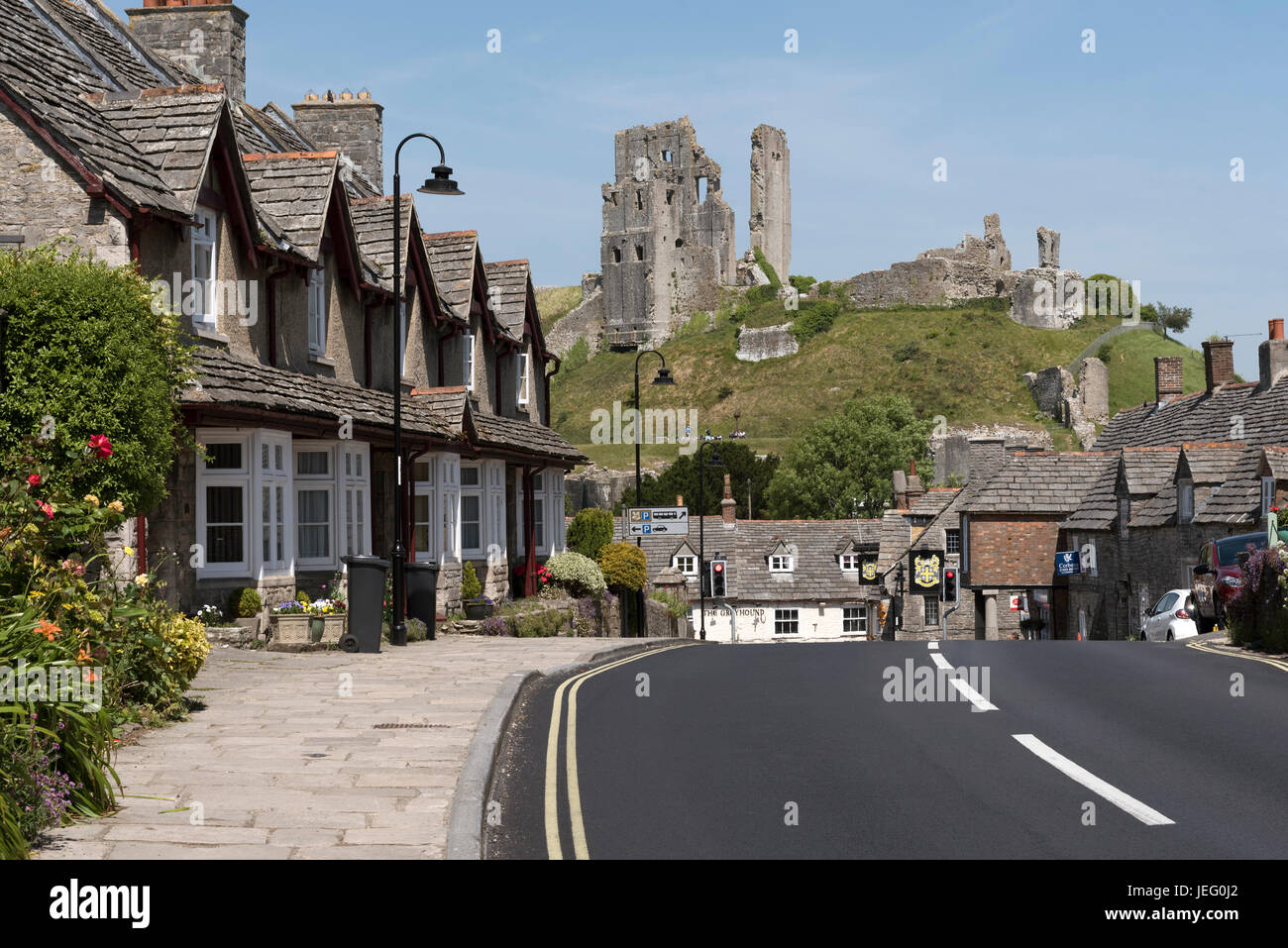 The main road through Corfe Castle a historic Dorset town with a ruined ...