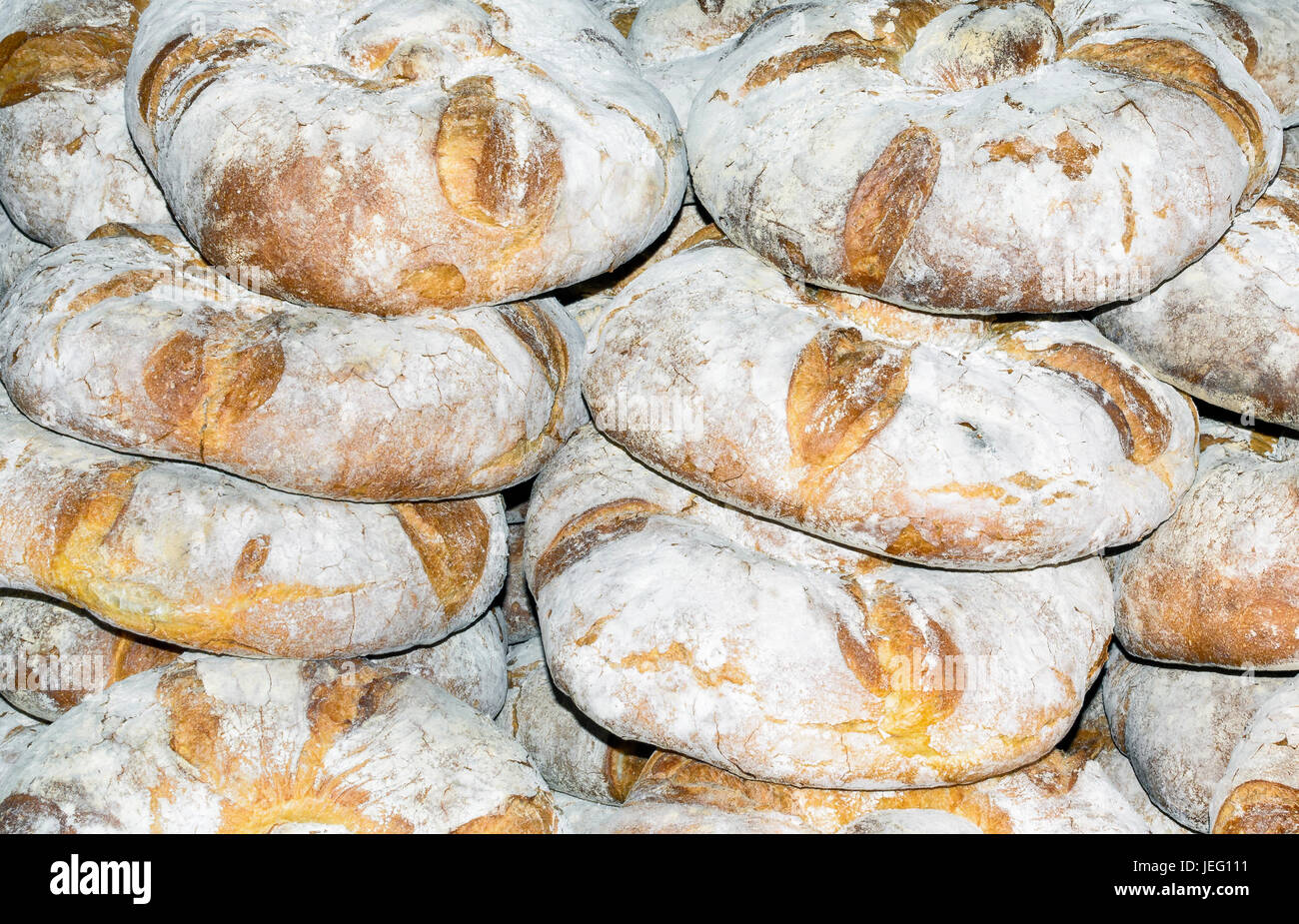 Big round breads for sale, at a medieval bakery stall. Flour over them ...