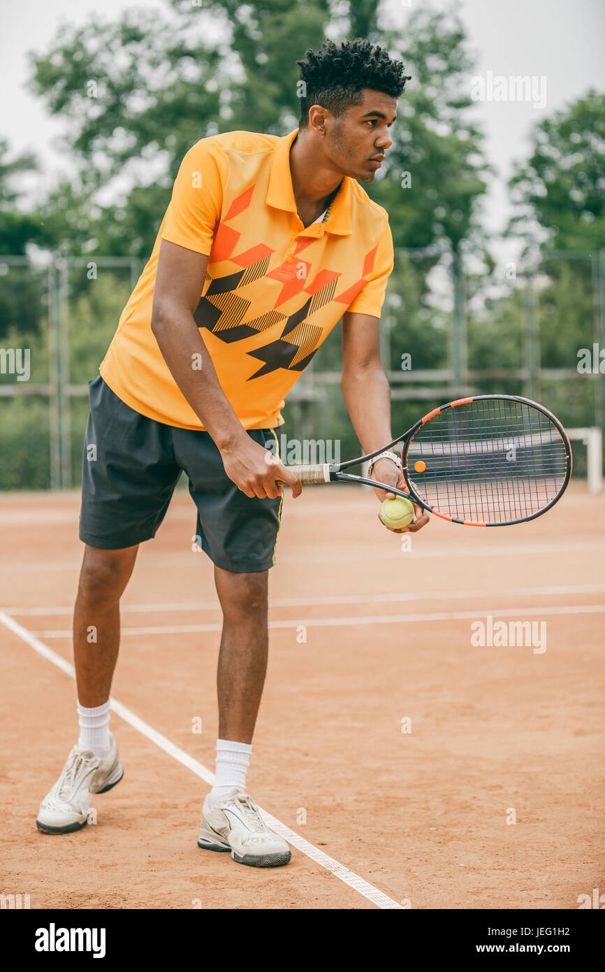 Young tennis player with racket ready to serve a tennis ball Stock ...