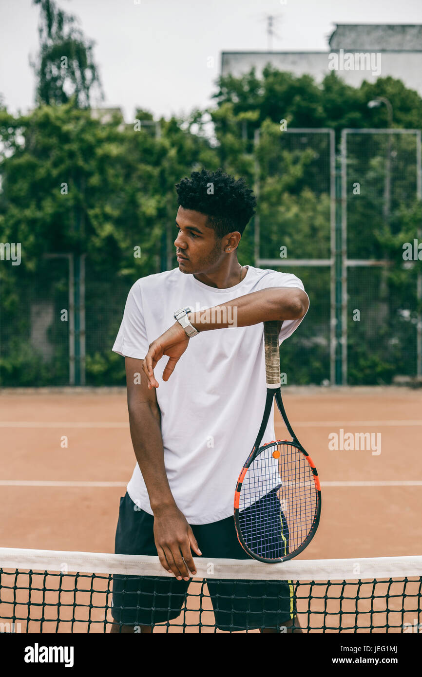 Confident young player holding tennis racket Stock Photo - Alamy