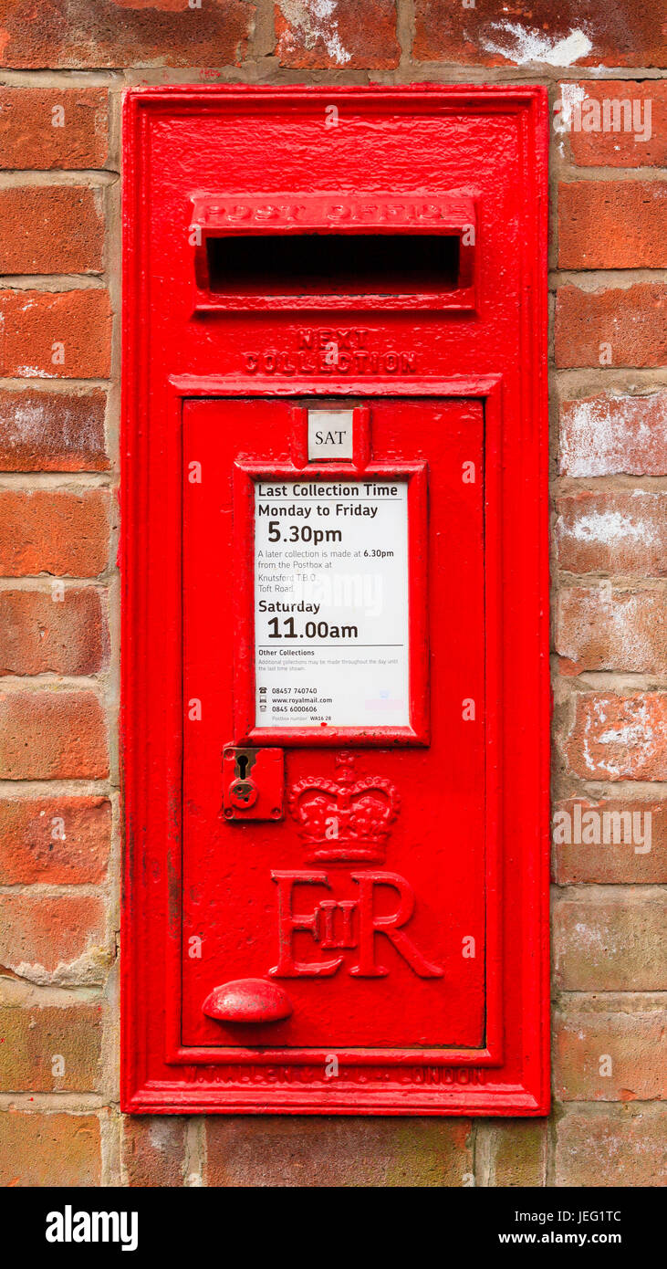 Red English letterbox. A traditional red English letterbox mounted in a ...