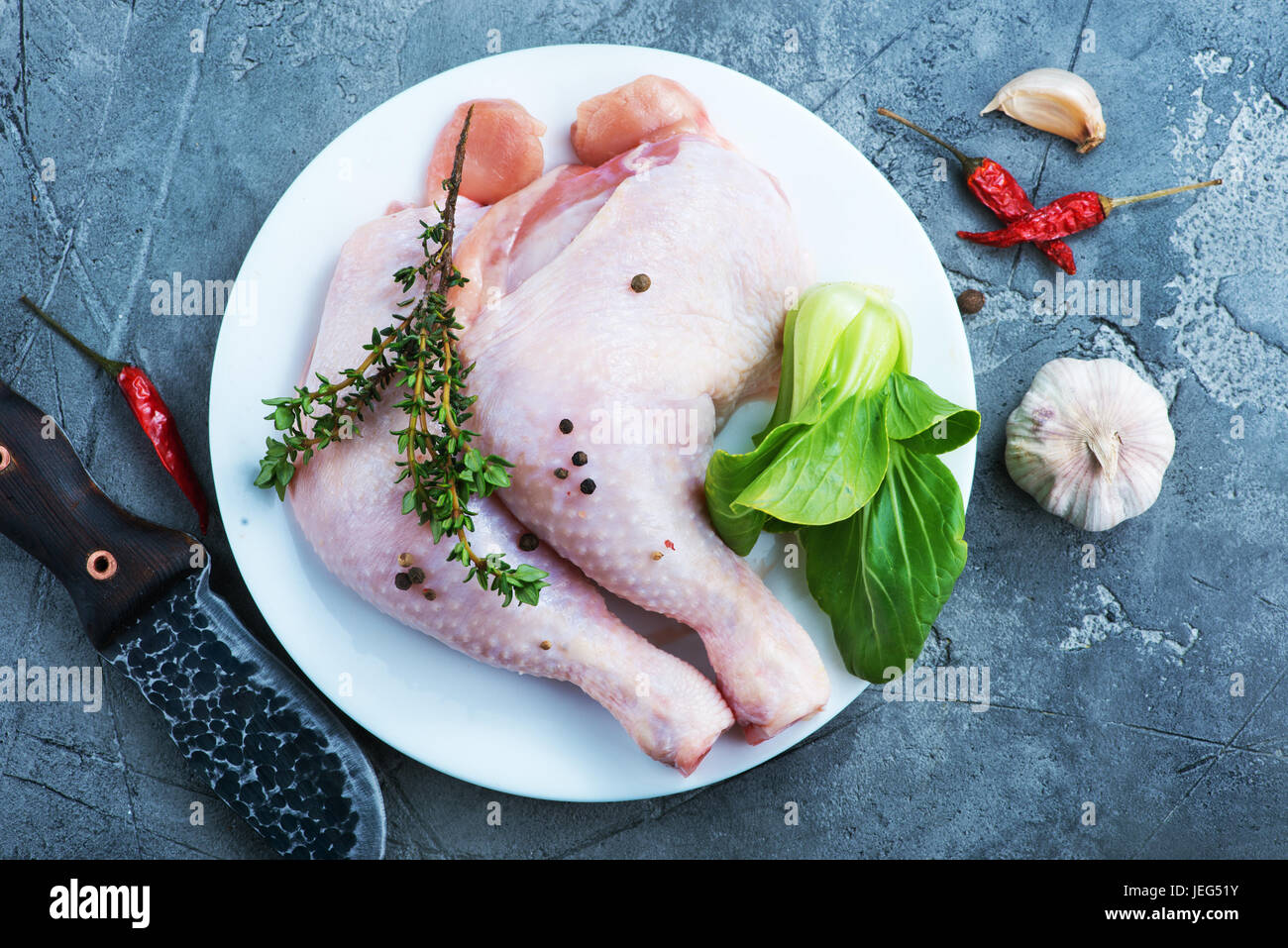 raw chicken legs on plate and on a table Stock Photo - Alamy