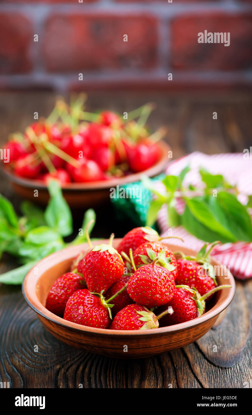 strawberry in bowl and on a table Stock Photo - Alamy