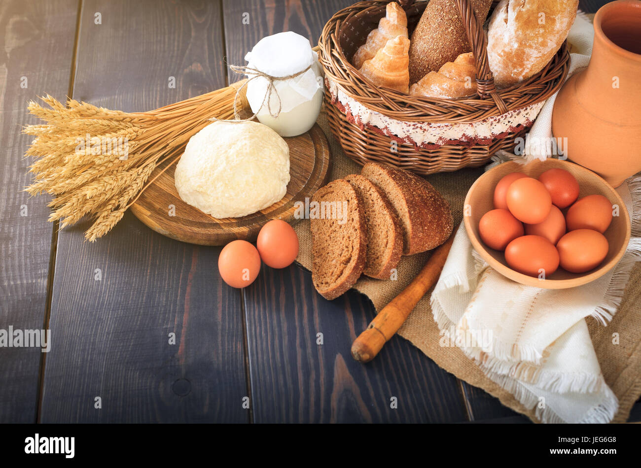 Breakfast from farm products: eggs, milk, fresh bread on a wooden table ...