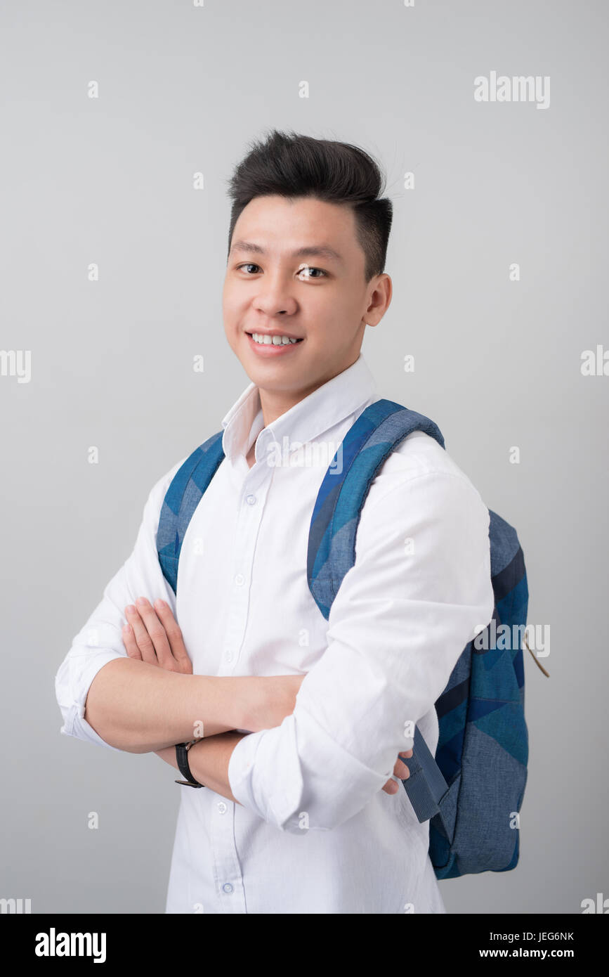 Portrait of good looking asian male student over gray background Stock ...