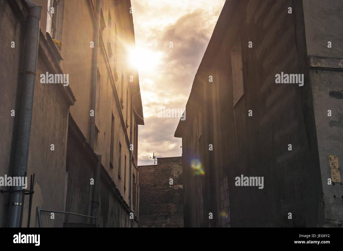 sunlight between tenement buildings in old town Stock Photo - Alamy