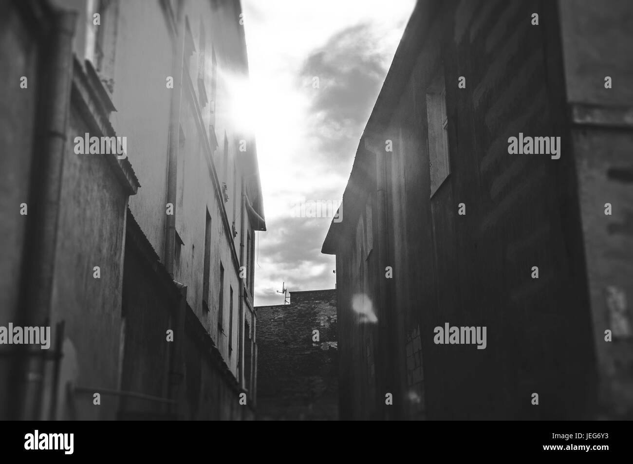 sunlight between tenement buildings in old town black and white dreamy ...