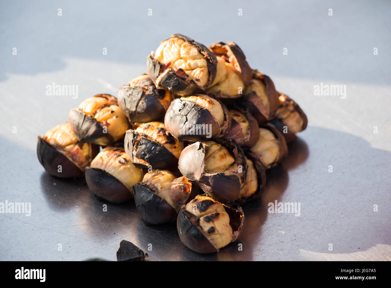 Organic brown chestnuts roasted over a hot fire Stock Photo - Alamy