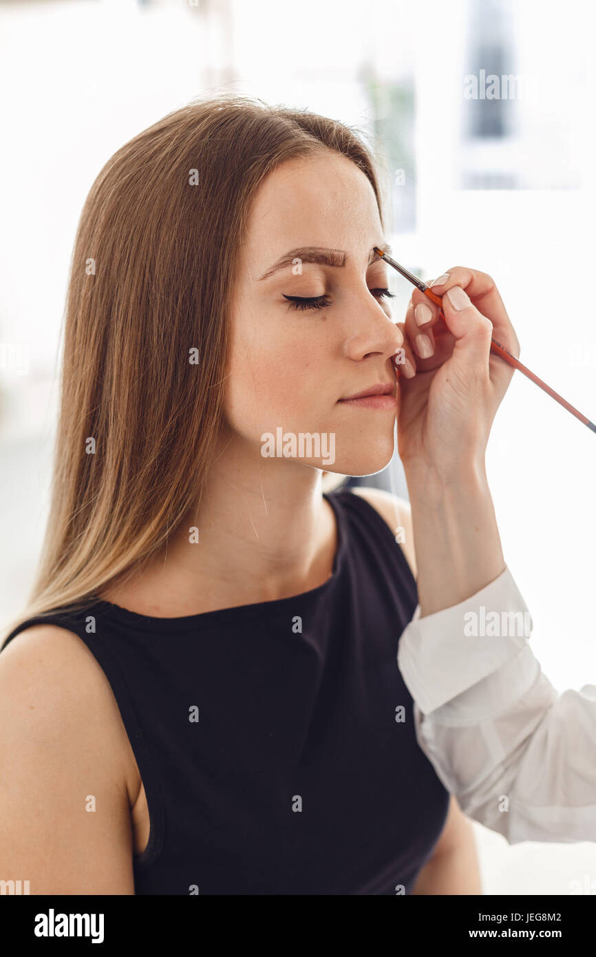 Portrait of a beautiful customer girl during an eyebrow correction ...