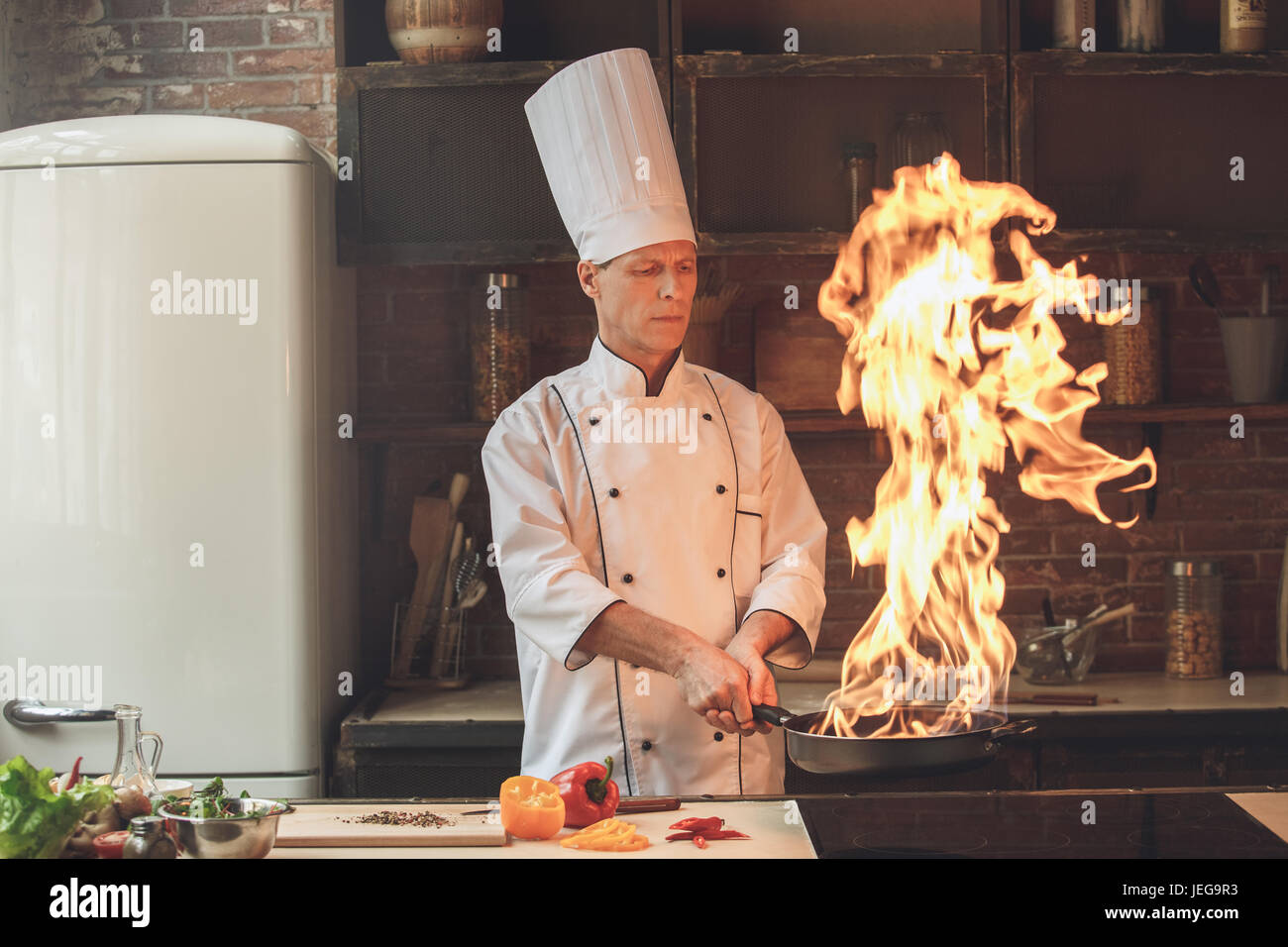 Mature male professional chef cooking meal indoors frying Stock Photo ...