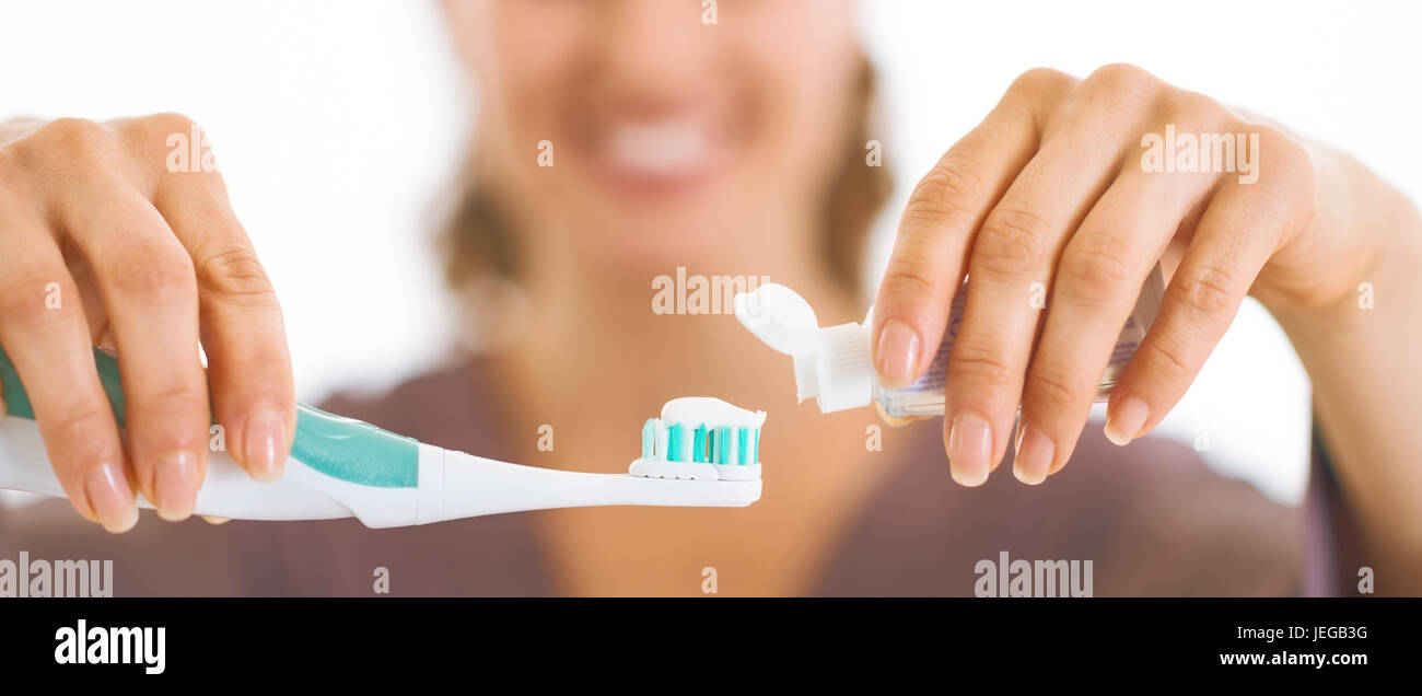 Closeup on happy young woman squeezing toothpaste from tube Stock Photo ...