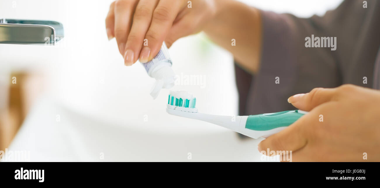 Closeup on young woman squeezing toothpaste on toothbrush Stock Photo ...