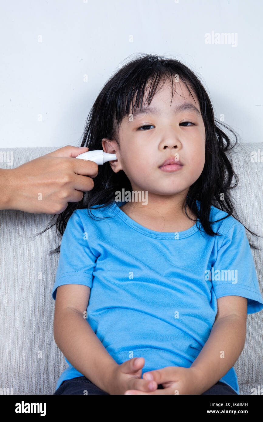 Asian Chinese little girl getting ear measurement for fever temperature ...