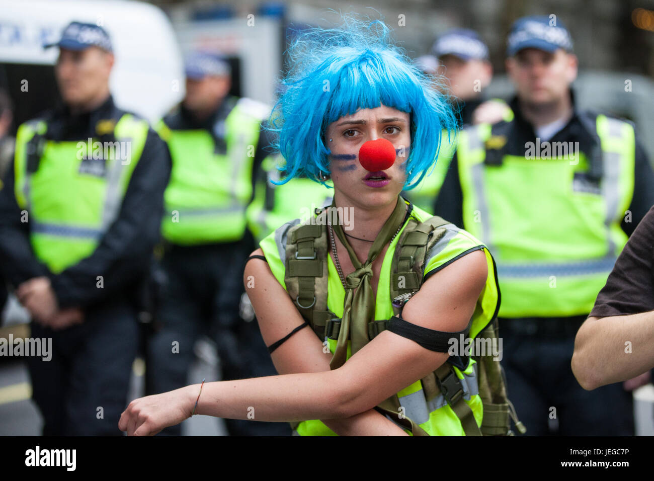 London, UK. 24th June, 2017. A clown performs in front of police lines ...