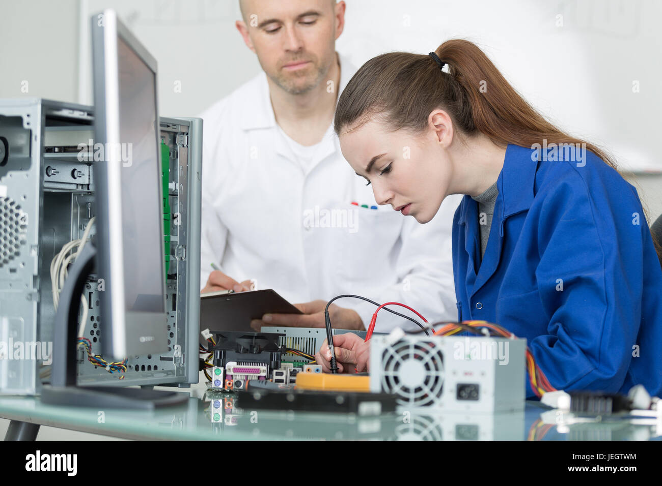 teacher with student in technology repairing computer Stock Photo - Alamy