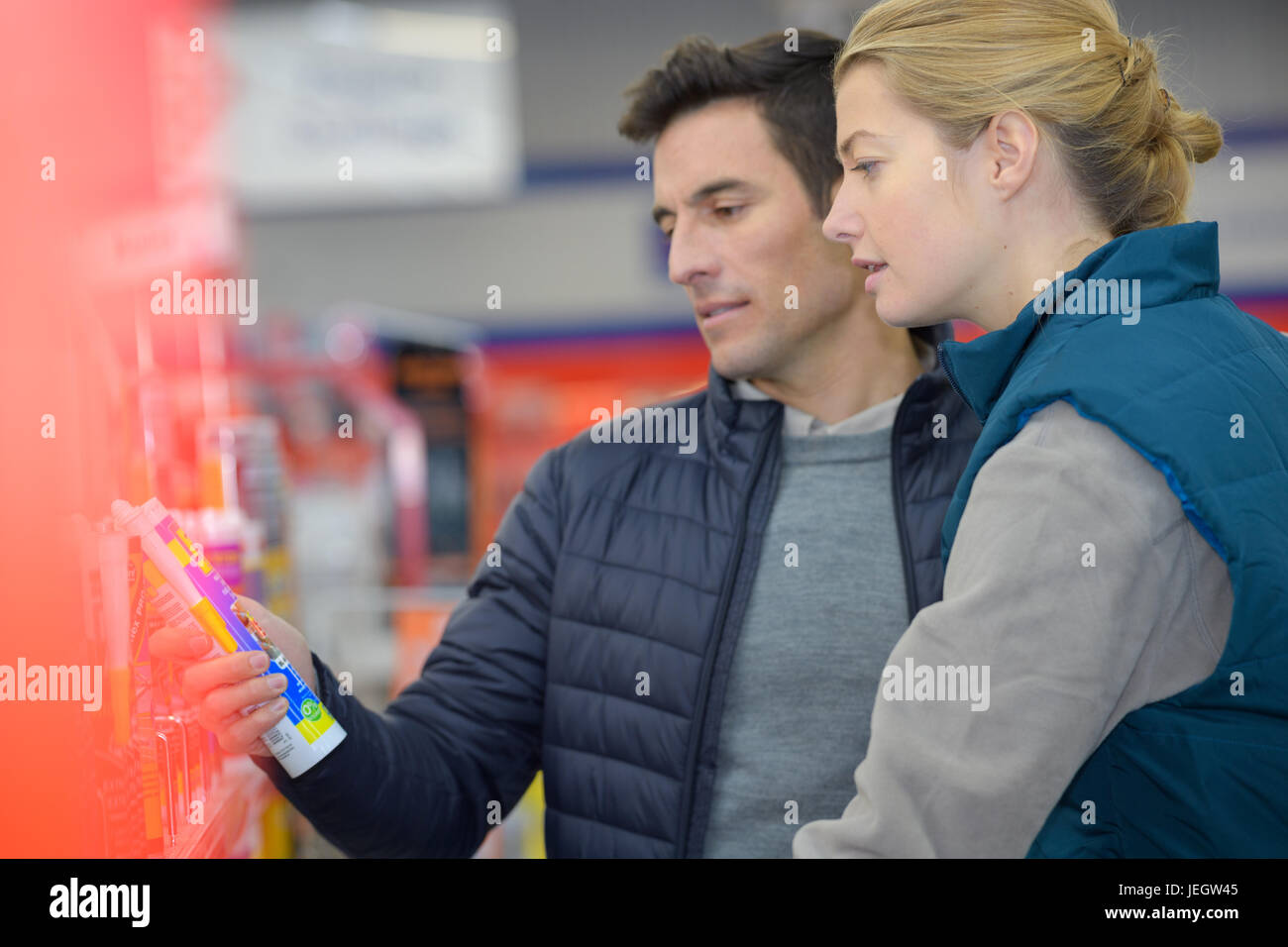 hardwarer store worker helping customer to choose silicone Stock Photo ...