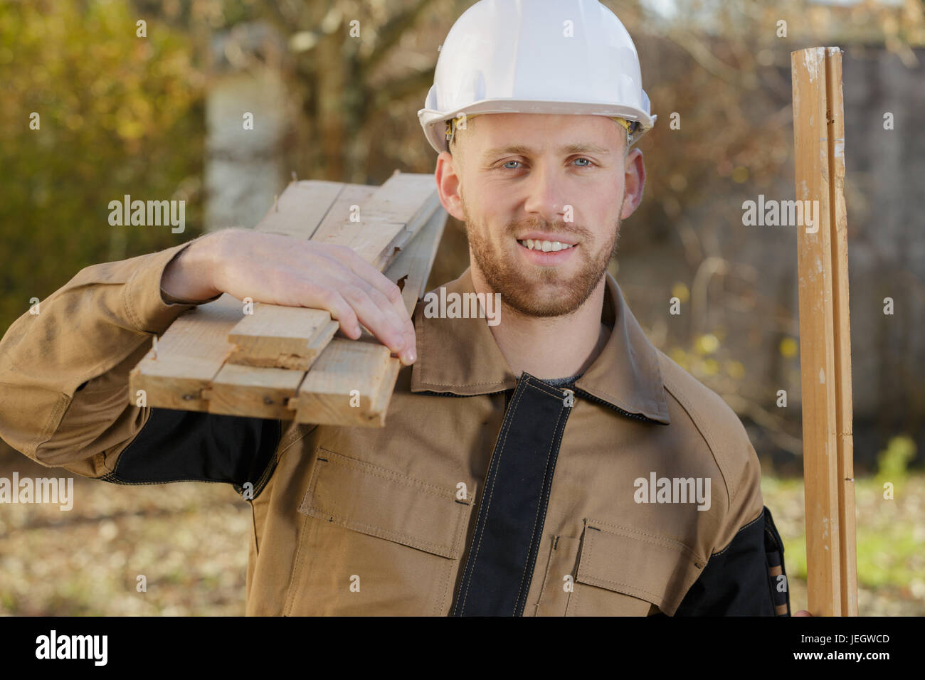 man carrying lumber Stock Photo - Alamy