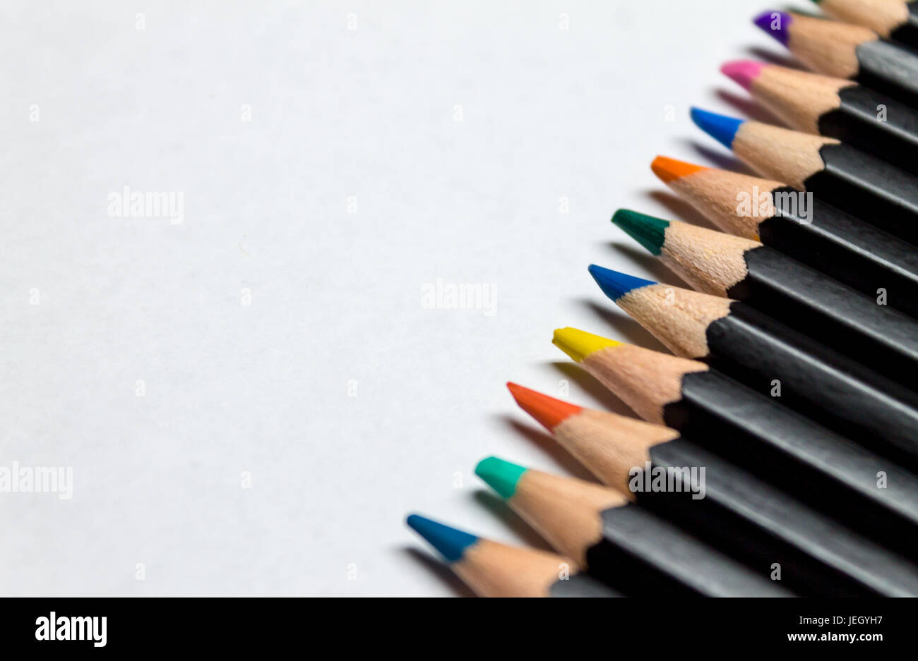 Colored pencils across white paper Stock Photo - Alamy