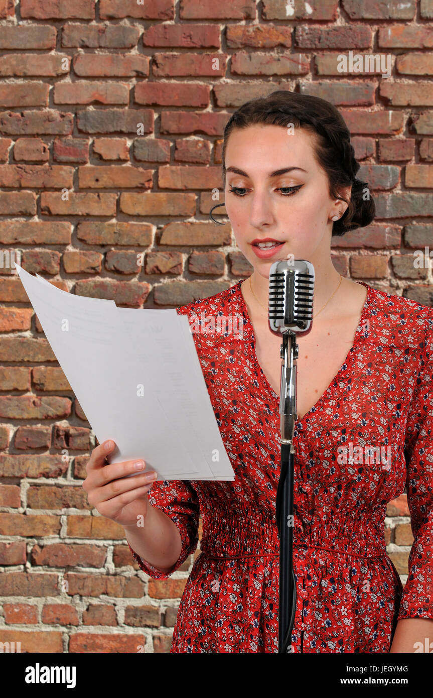 Woman speaking into a vintage microphone performing a radio play Stock ...
